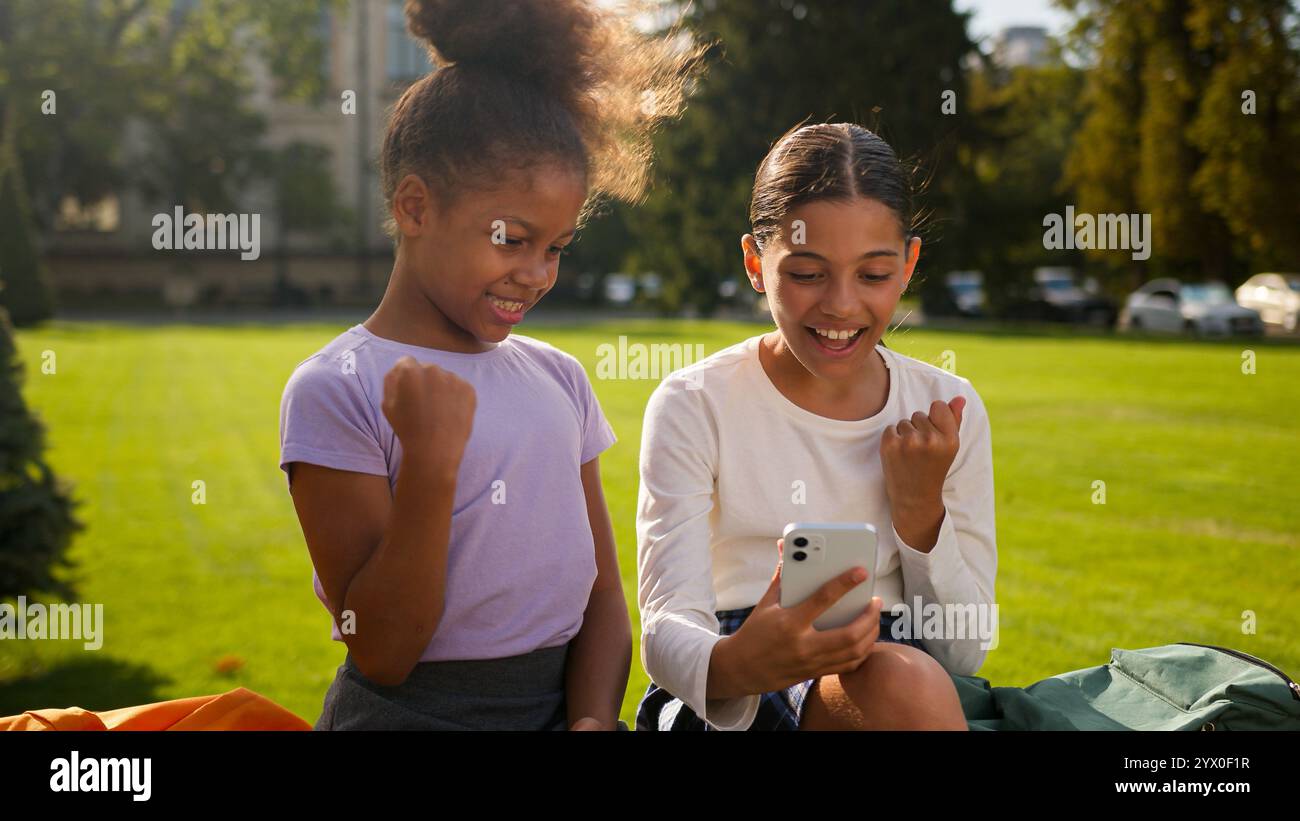 Multiracial school students pupils schoolgirls girls using mobile phone ...