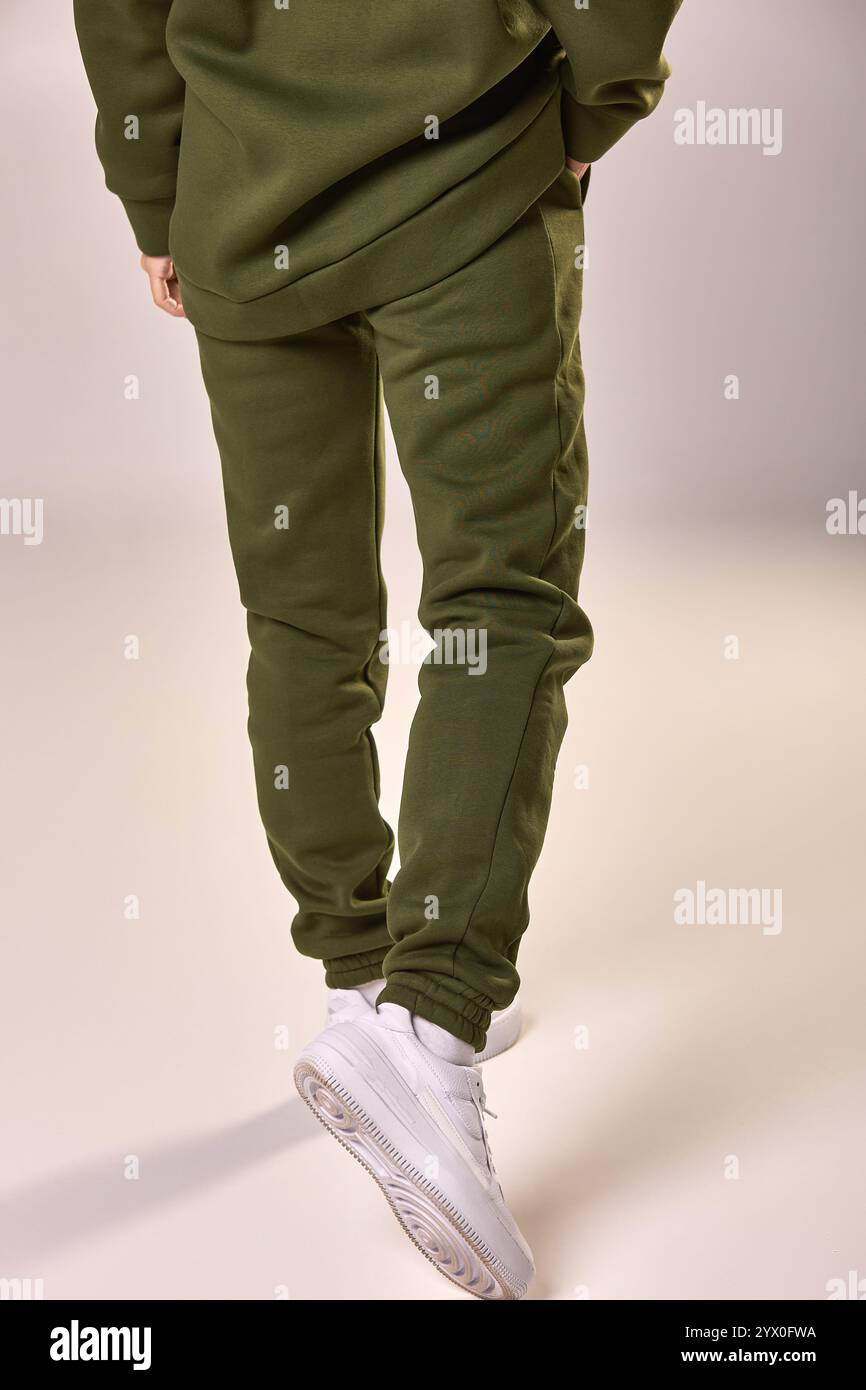 Olive green tracksuit and casual sneakers on male model showcasing ...