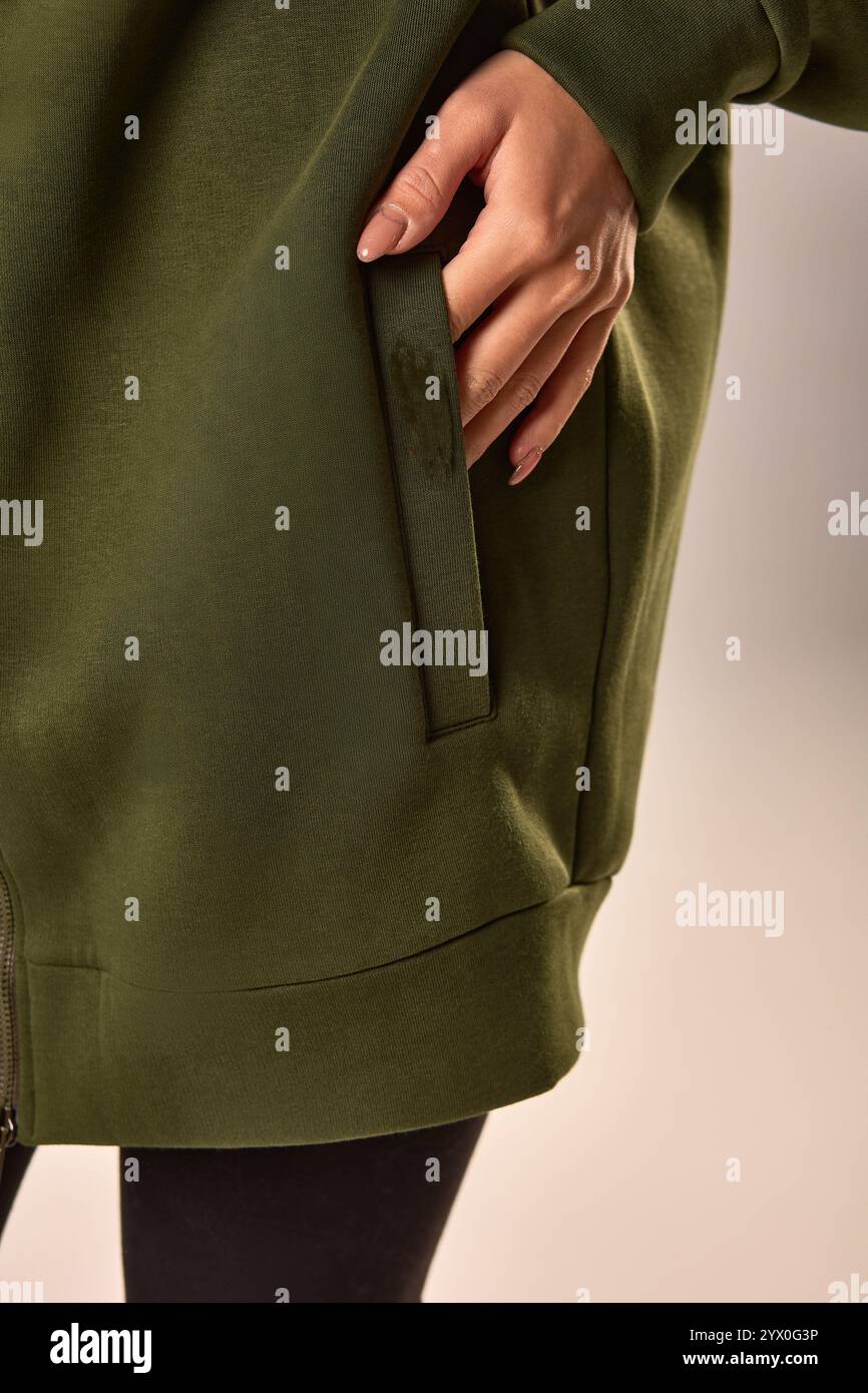 Hand in closeup touching green fabric under natural lighting ...