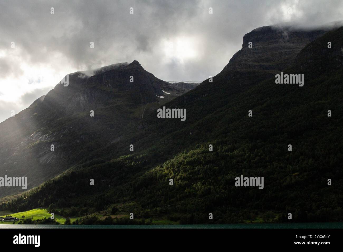 Beams of light pierce through the rugged mountains, illuminating the ...