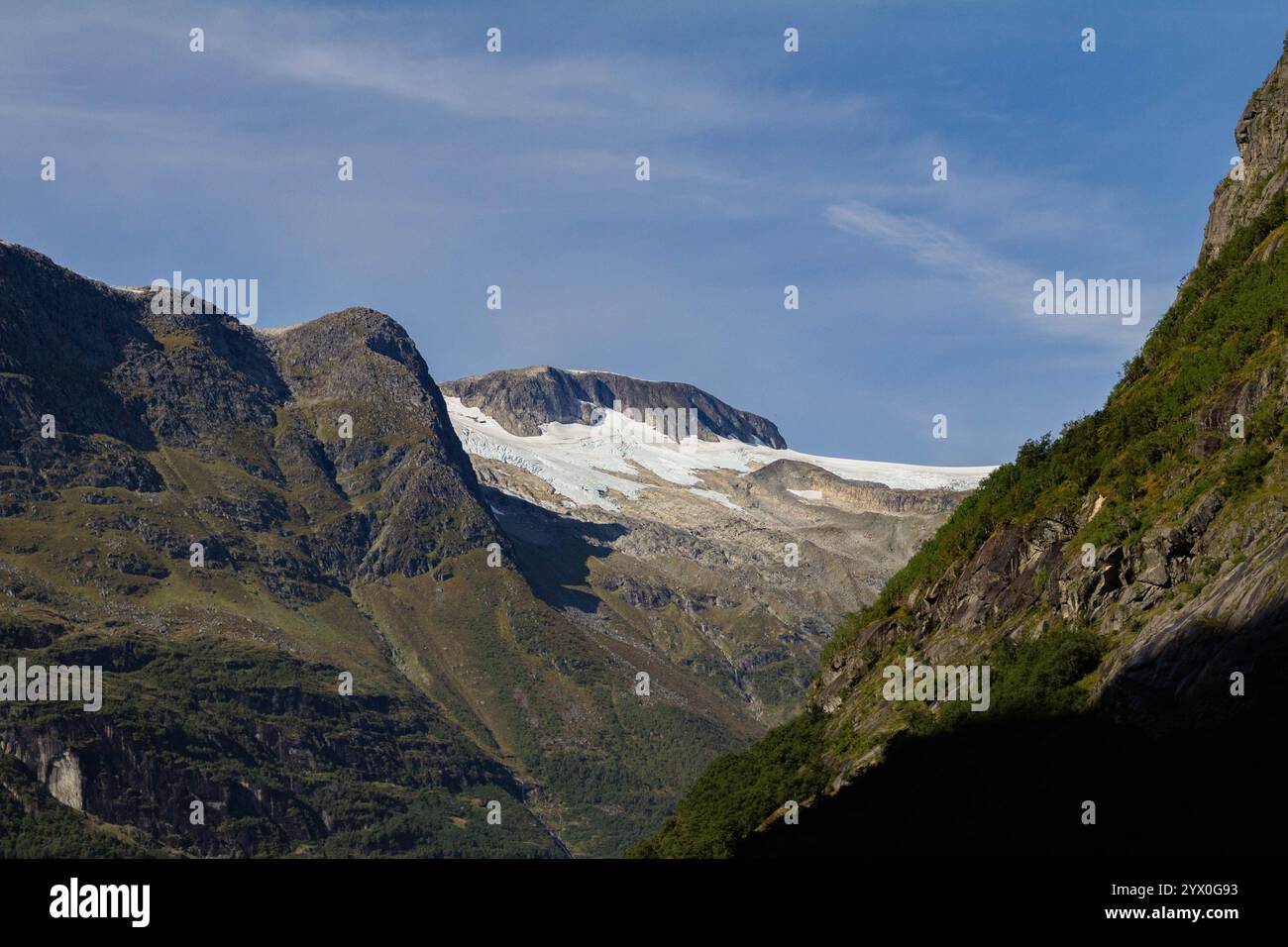 A stunning glacier stretches across the rugged mountain, its icy ...