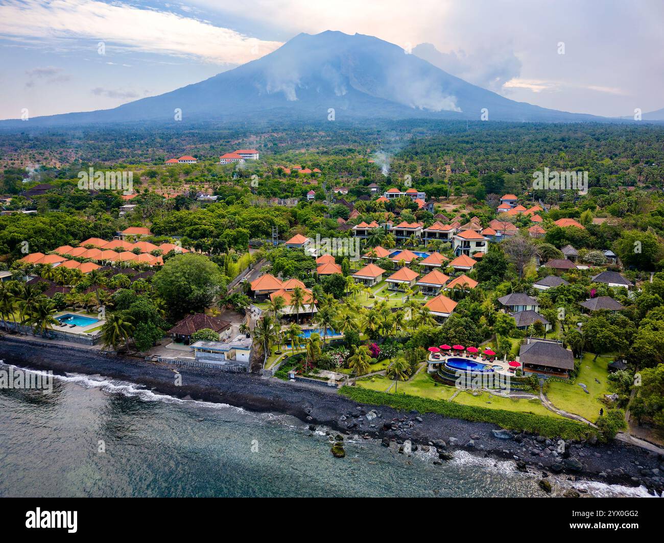 Aerial view of the towering volcano Mount Agung and tropical resort ...