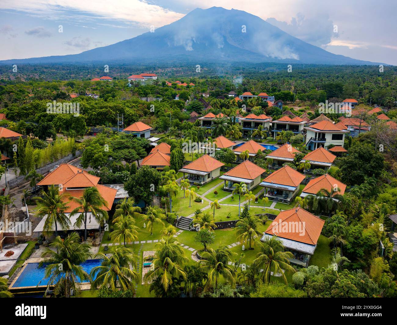 Aerial view of the towering volcano Mount Agung and tropical resort ...