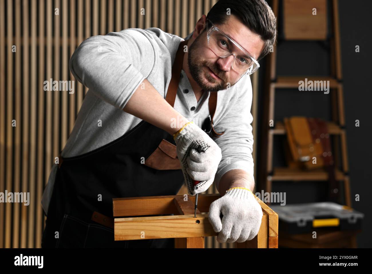Professional carpenter repairing wooden stool in workshop Stock Photo ...
