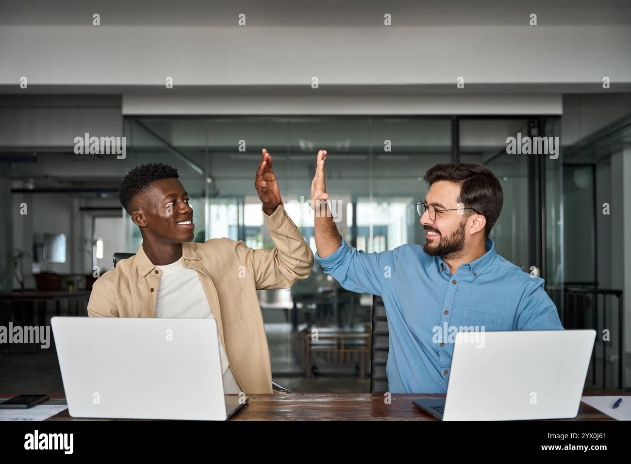 Happy diverse professional male employees team giving high five at work ...