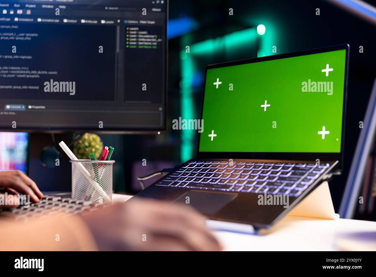 African american programmer working on cloud computing next to green screen, writing code for ...