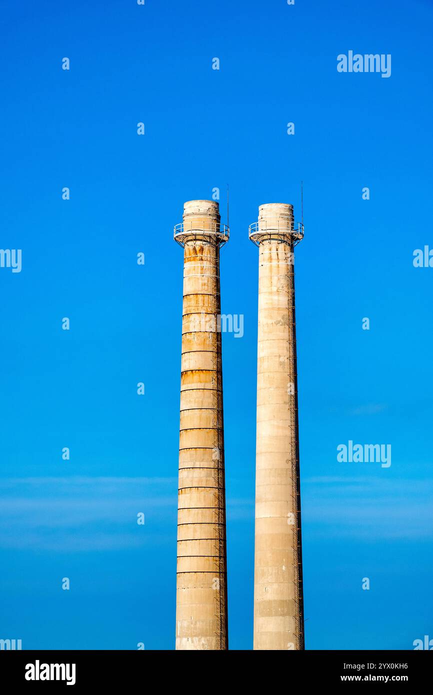 Two industrial chimney stacks reaching into a clear blue sky Stock ...