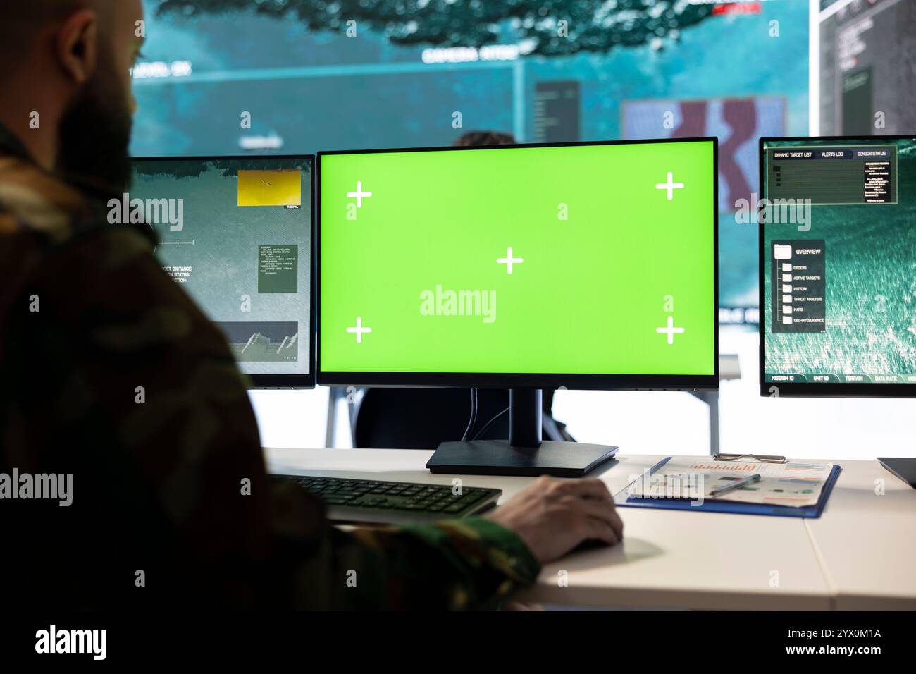 Soldier working on reconnaissance CCTV imagery on pc next to green ...