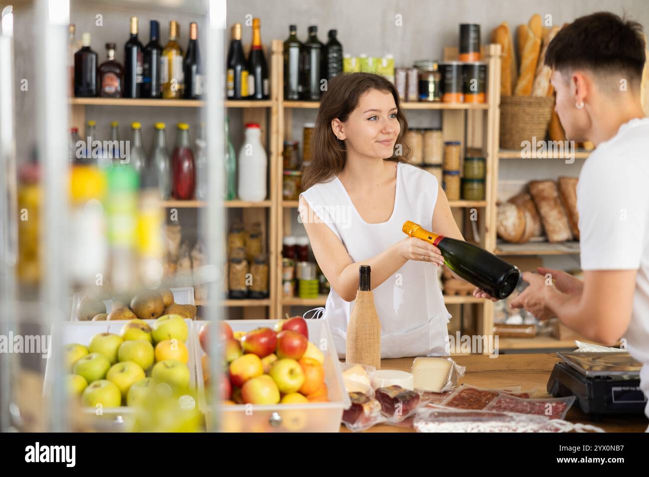 Smiling Salesgirl Offering Wine To Customer In Grocery Store Stock