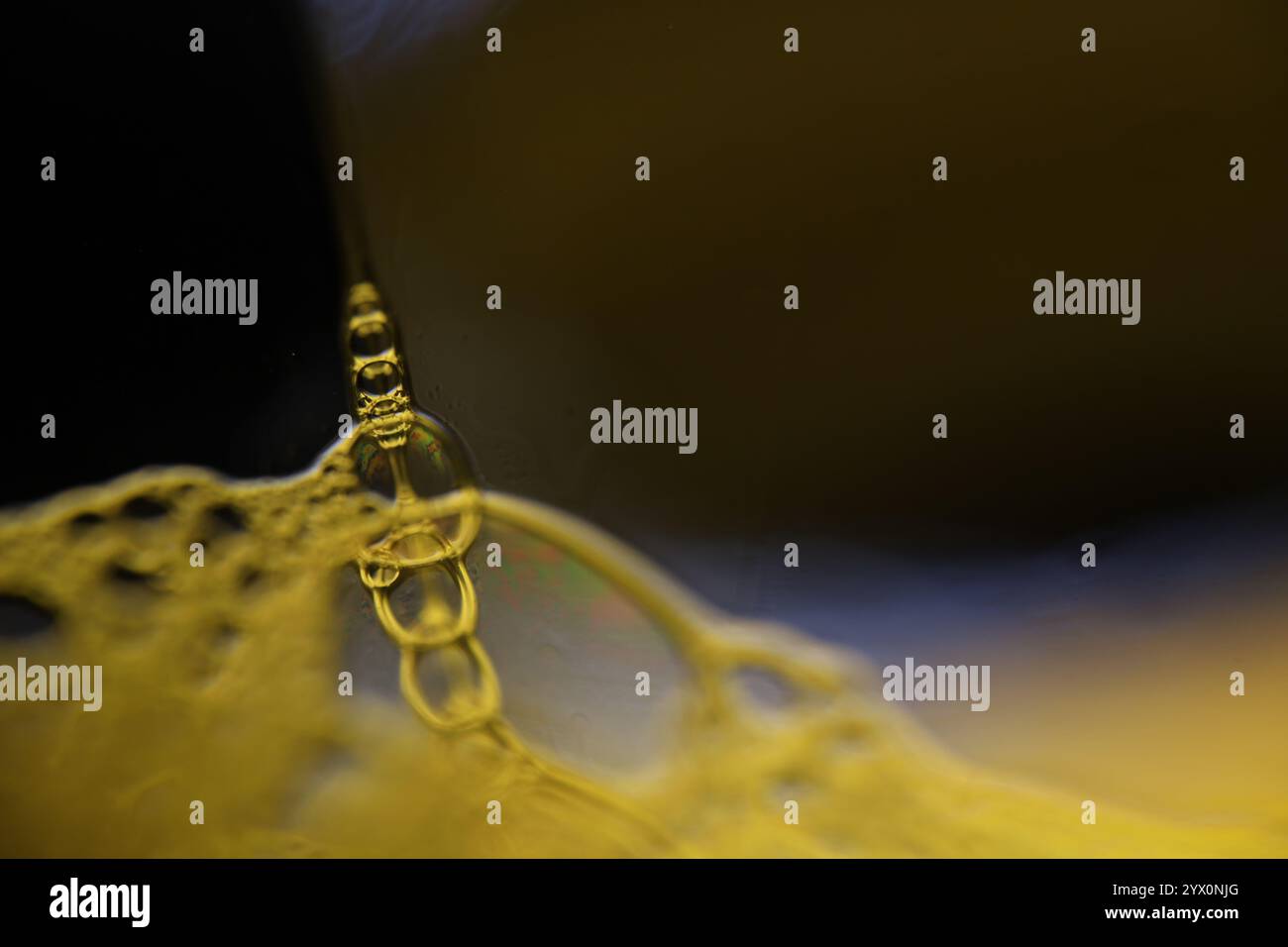 Yellow liquid reflections on black background, fluid abstraction ...