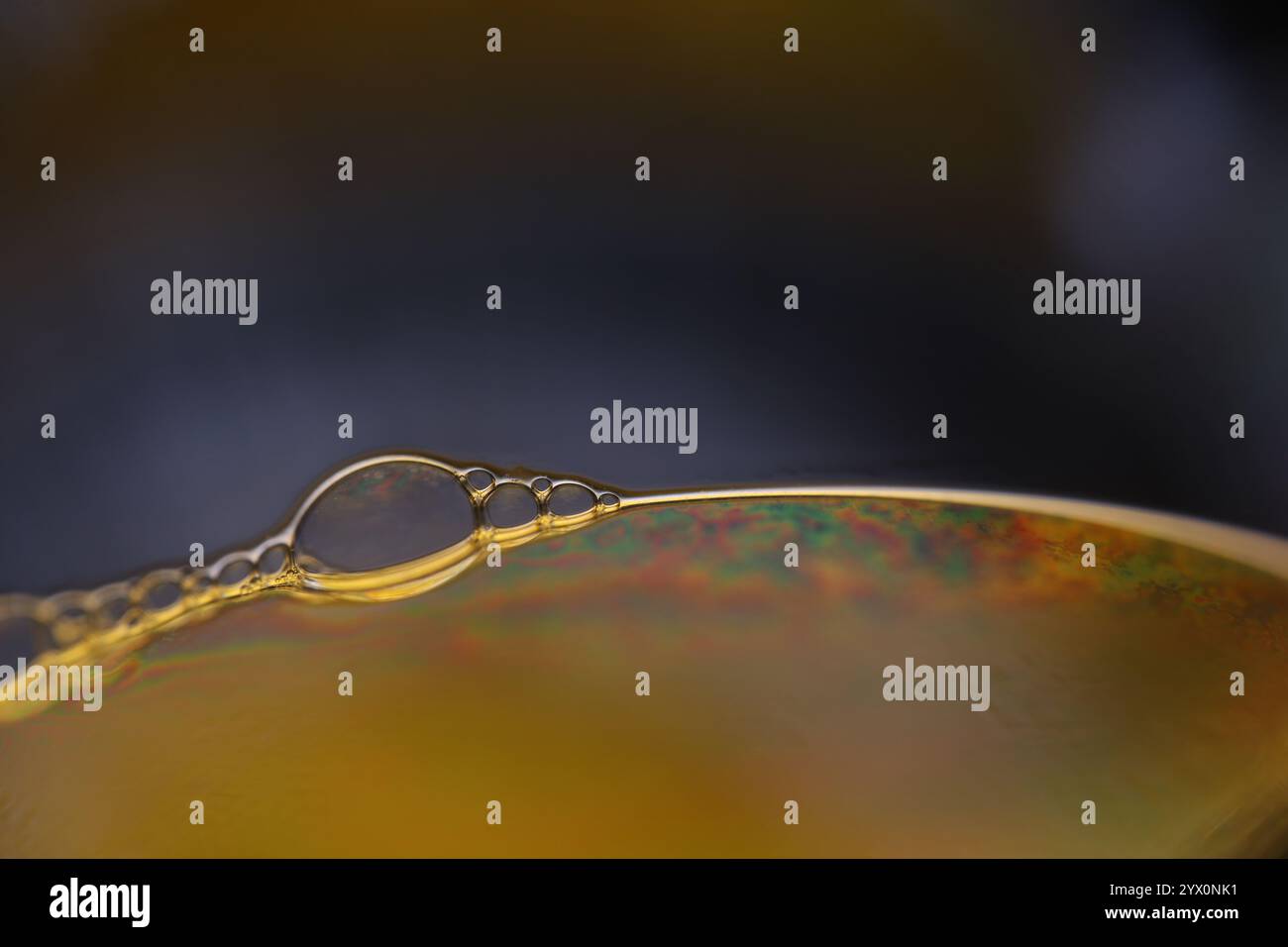 Yellow liquid reflections on black background, fluid abstraction ...