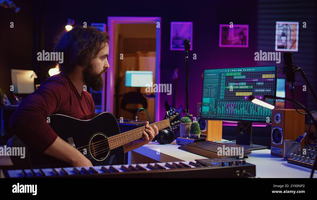 Music producer mixing guitar sounds played by him on acoustic ...