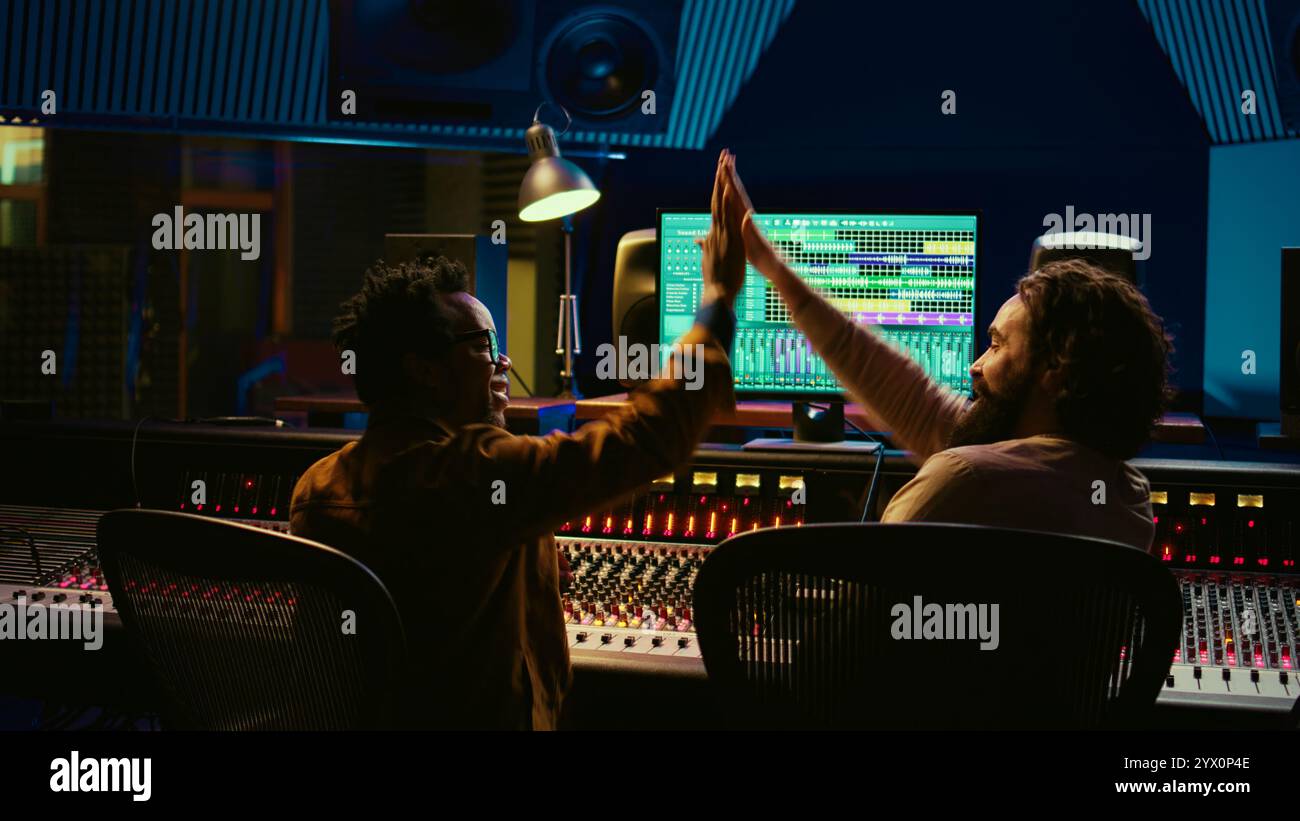 Musician and audio engineer sharing high five after creating a ...