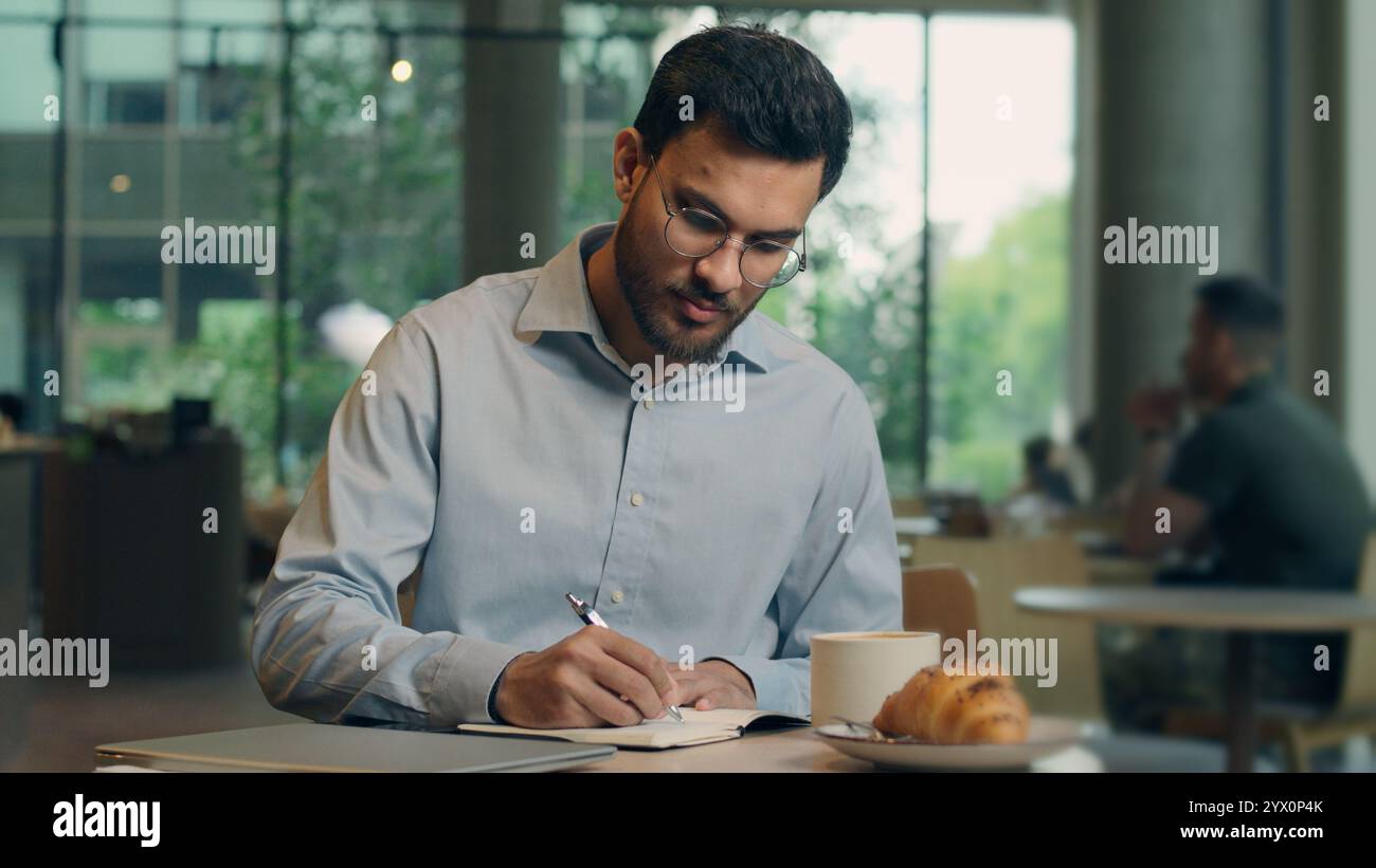 Arabian Indian business man guy education studying write notes in cafe ...