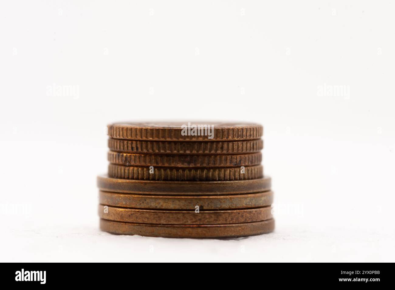 A stack of coins on a white background. The coins are of different ...