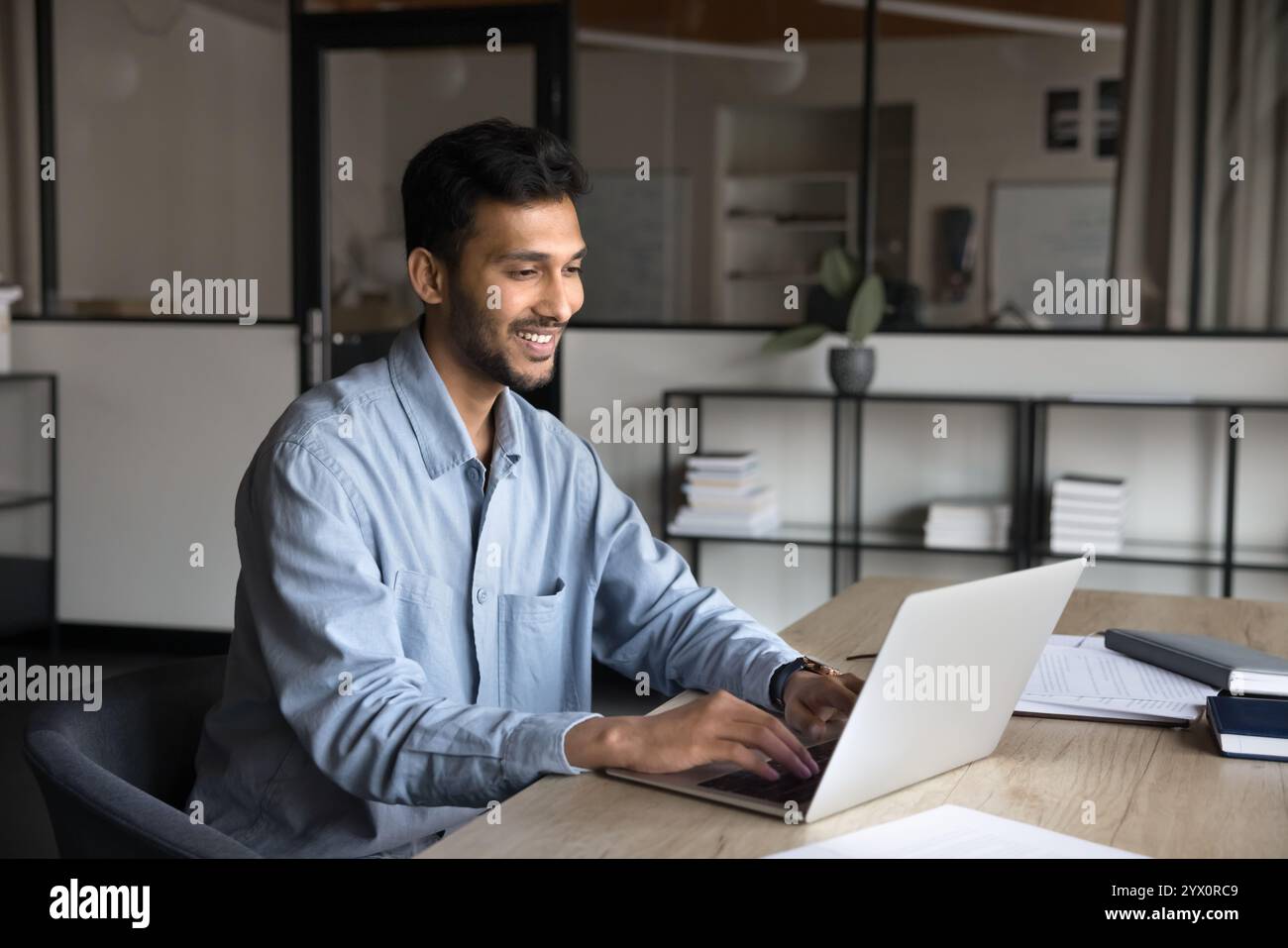 Indian man using laptop at modern workplace Stock Photo - Alamy