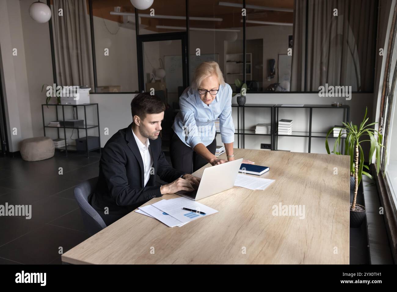 In modern office conference room two teammates working on project Stock ...