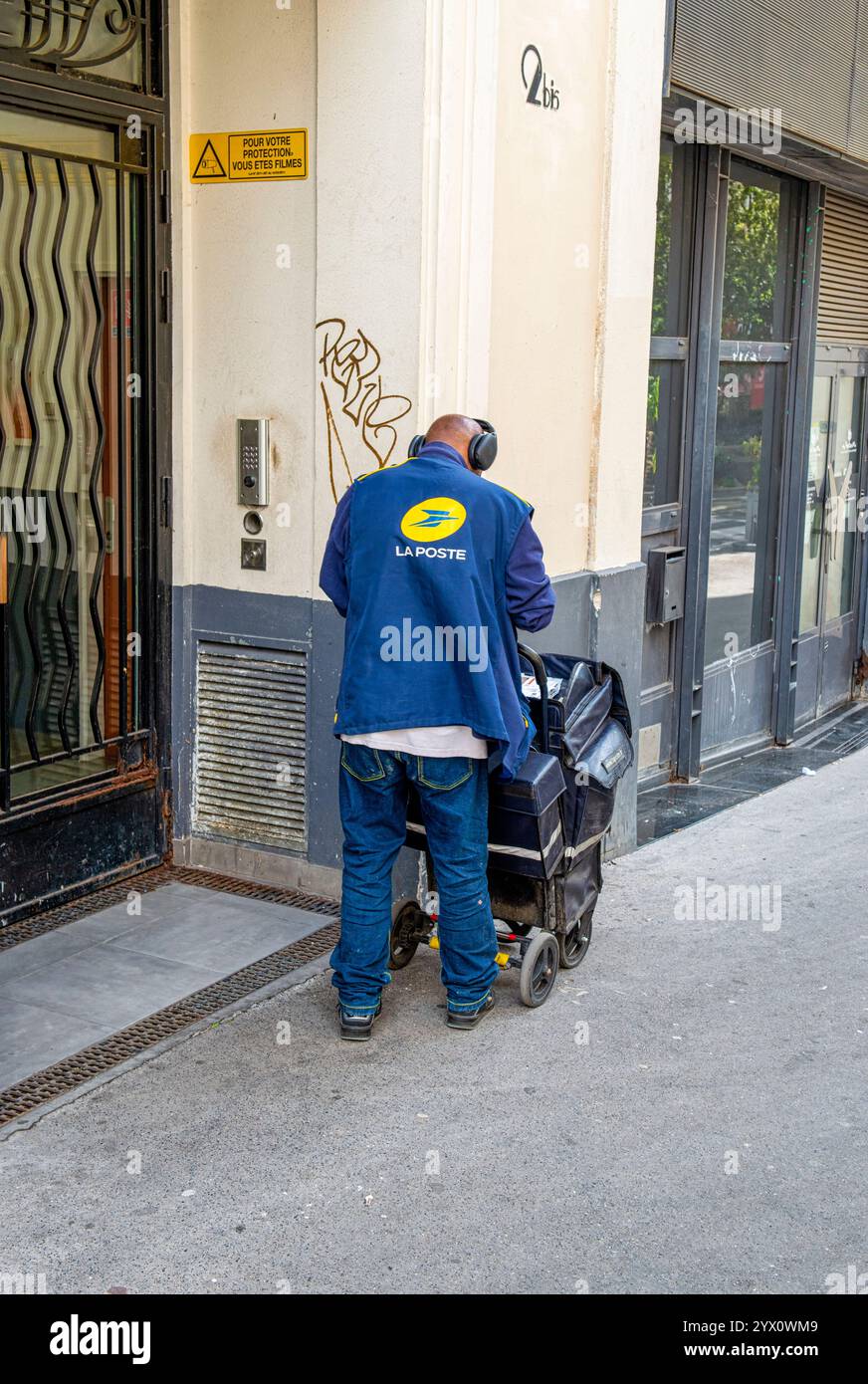 French Postman delivering the mail around the city streets of Paris ...