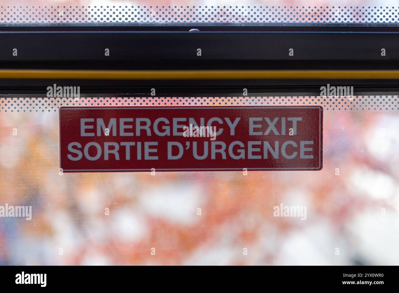 Close-up image of an 'Emergency Exit. Sortie D'Urgence' sticker on a ...