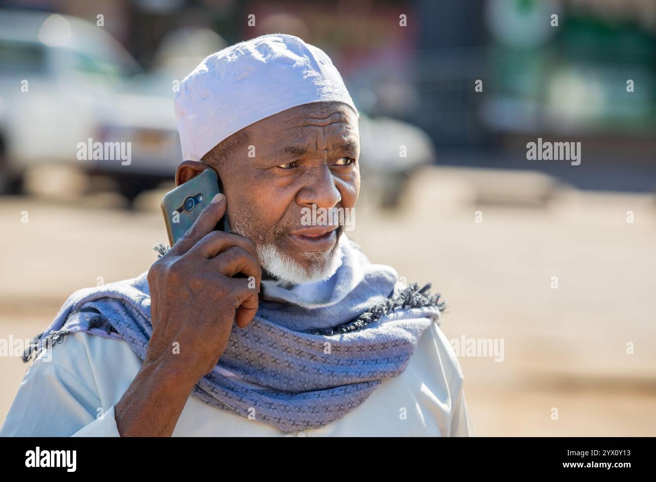 portrait of old african muslim man talking on the smartphone walking on ...