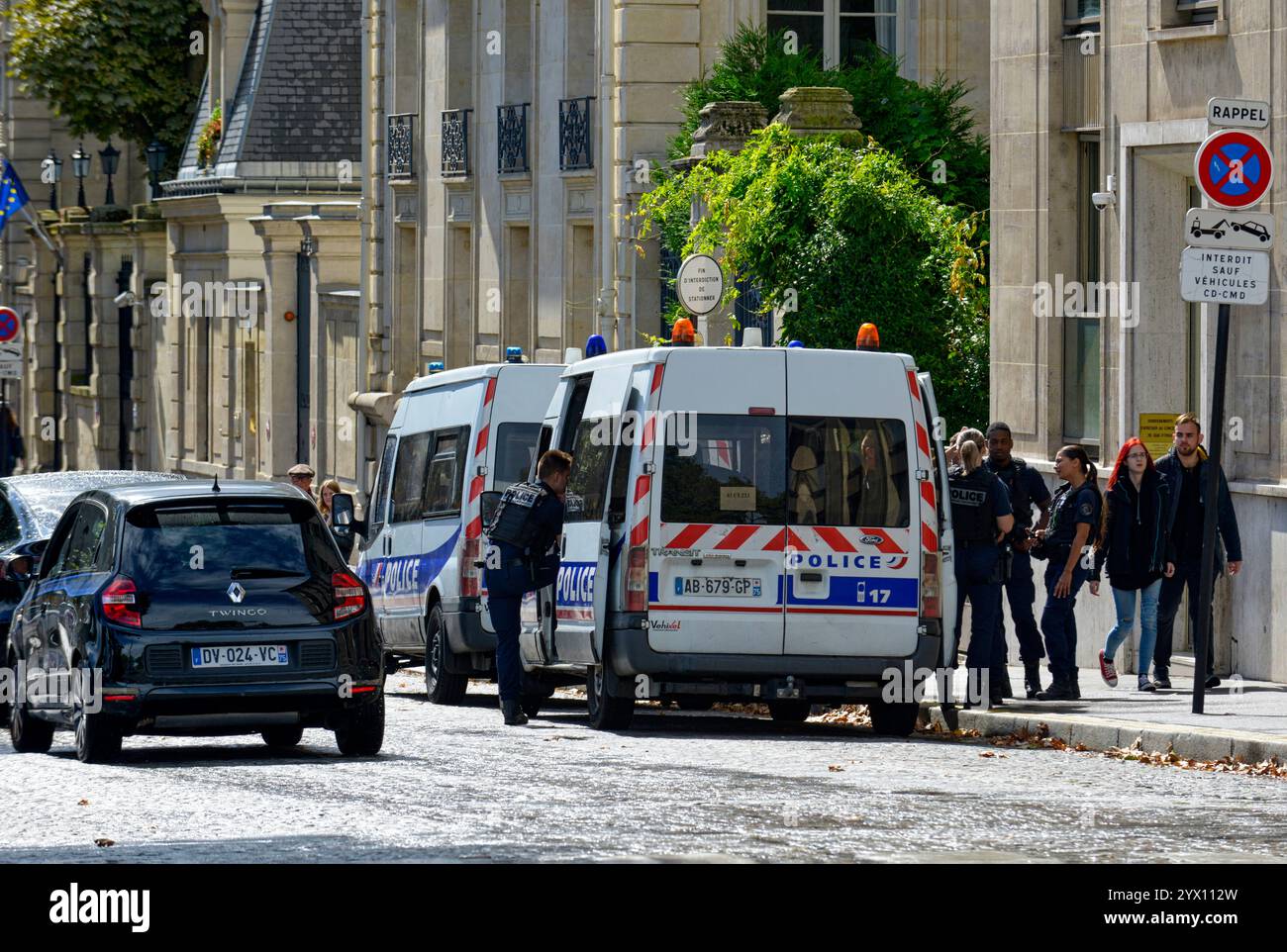 French Police men and women gathered around two vehicles on the street ...