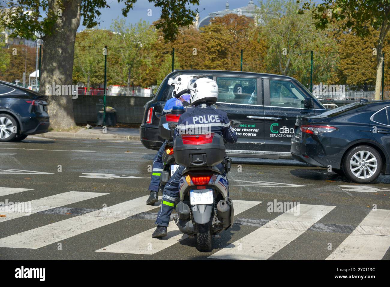 Two french police officers on scooters wait at an intersection in Paris ...