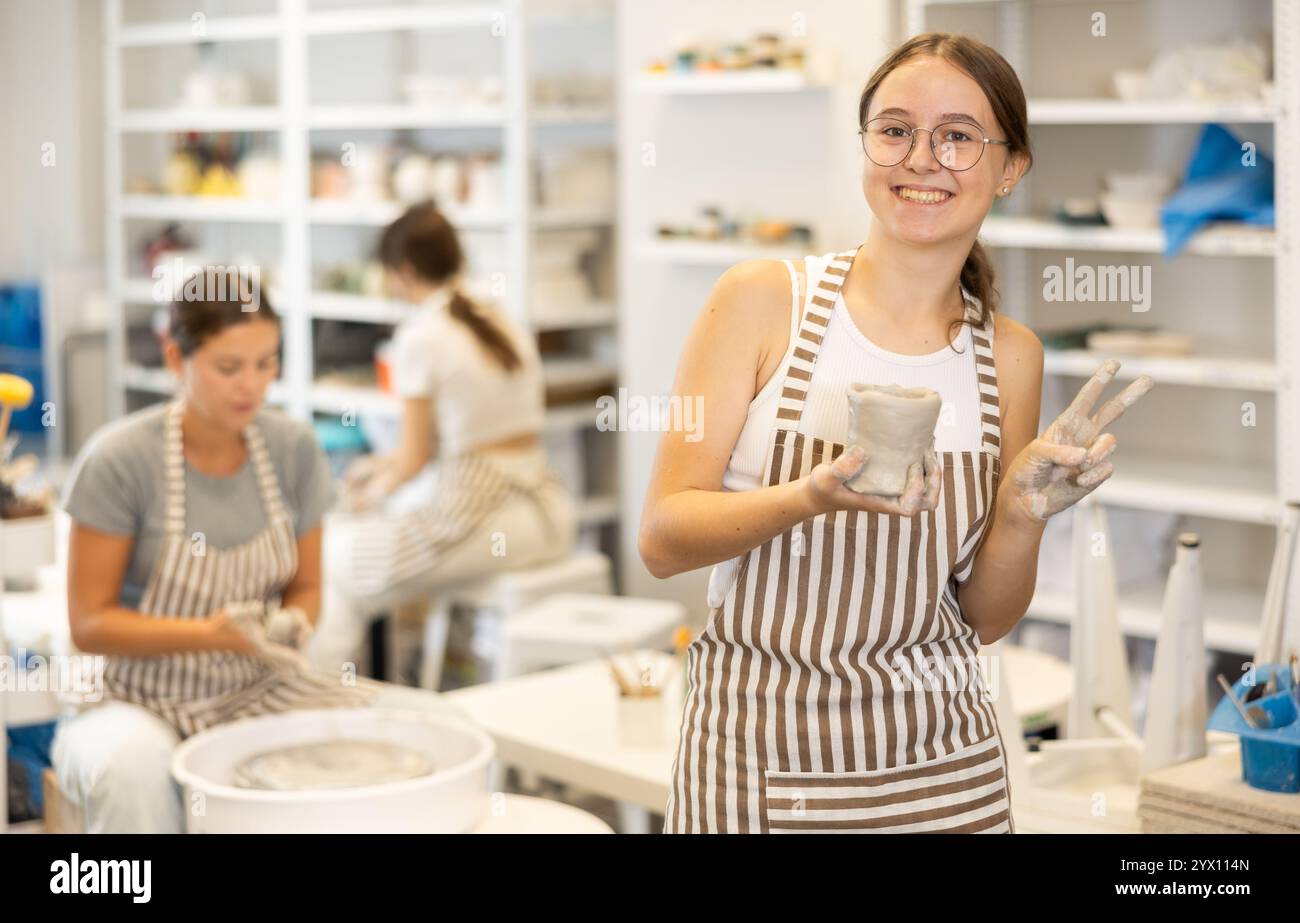 Teen girl takes break, rests, waves hello with her hands stained with ...