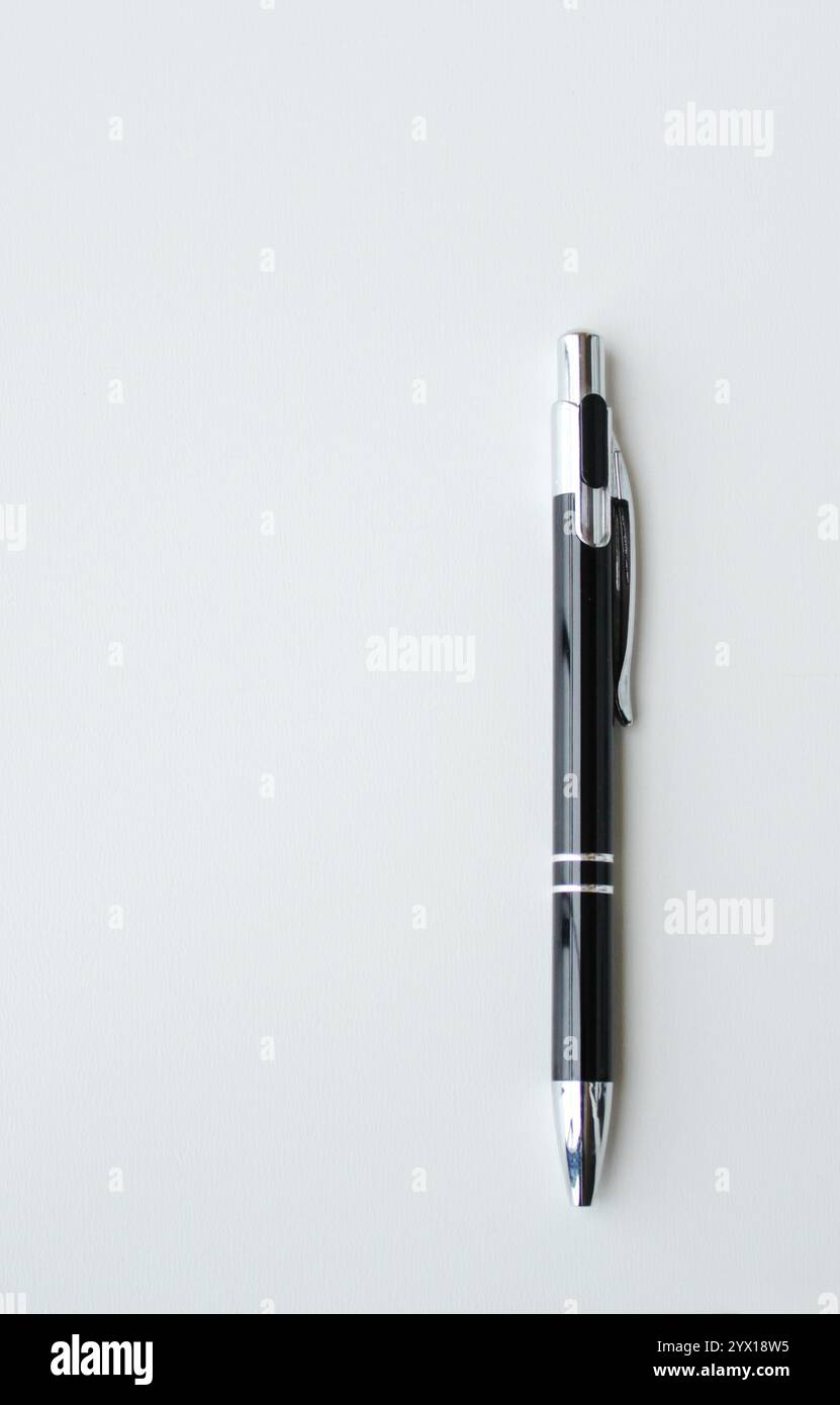 Elegant black ballpoint pen on vertical white background with copy ...