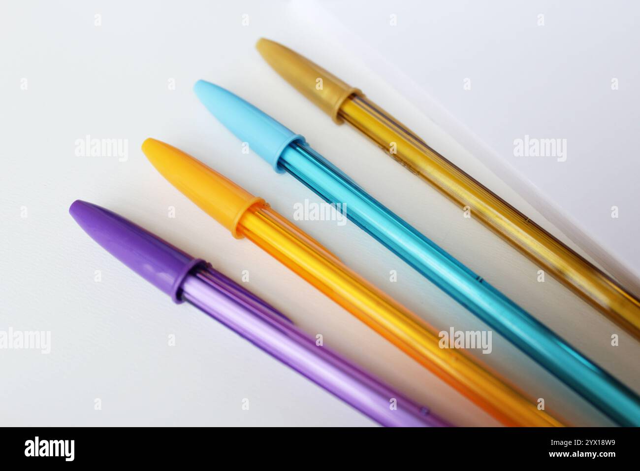 Four colorful pens arranged side by side in diagonal on white ...