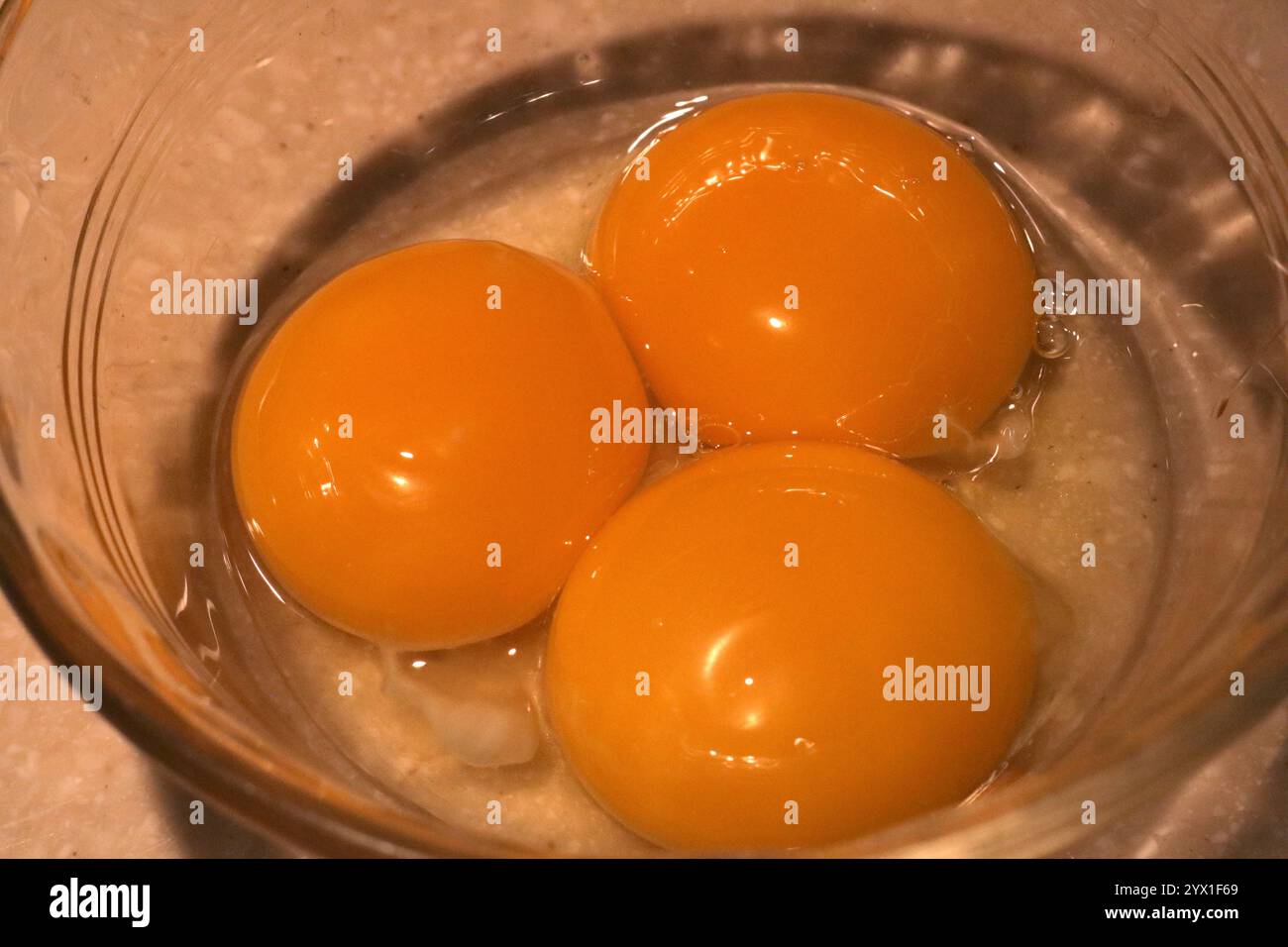 Three Fresh Egg Yolks in a Transparent Glass Bowl on a Light Surface ...