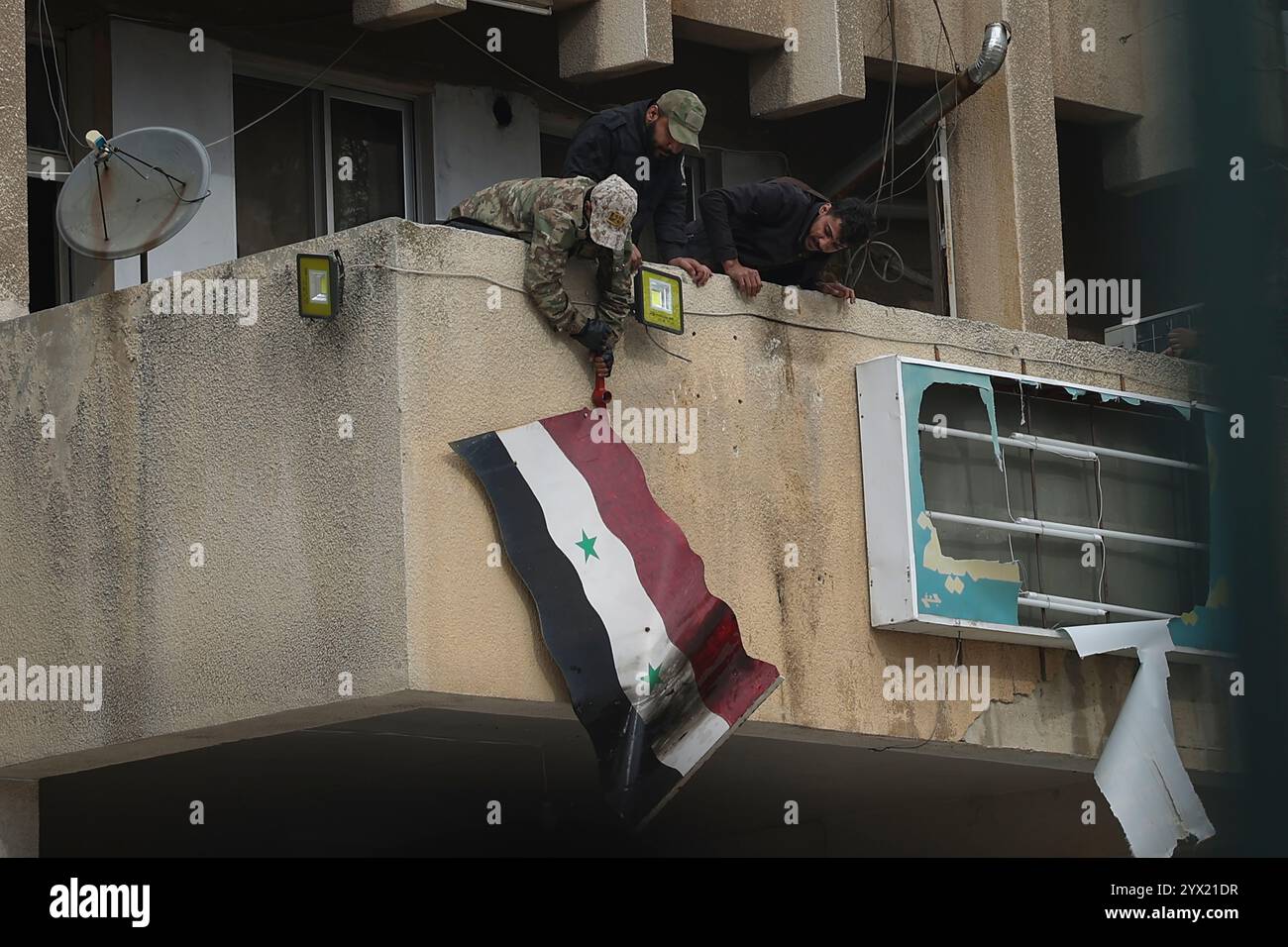 Syrian opposition fighters remove a government flag from an official ...