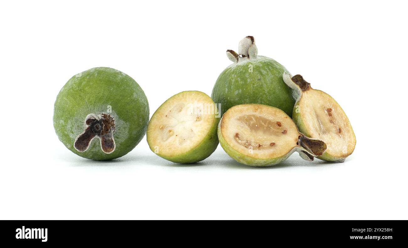 Close-up of fresh whole and sliced feijoa fruit displayed on a clean ...