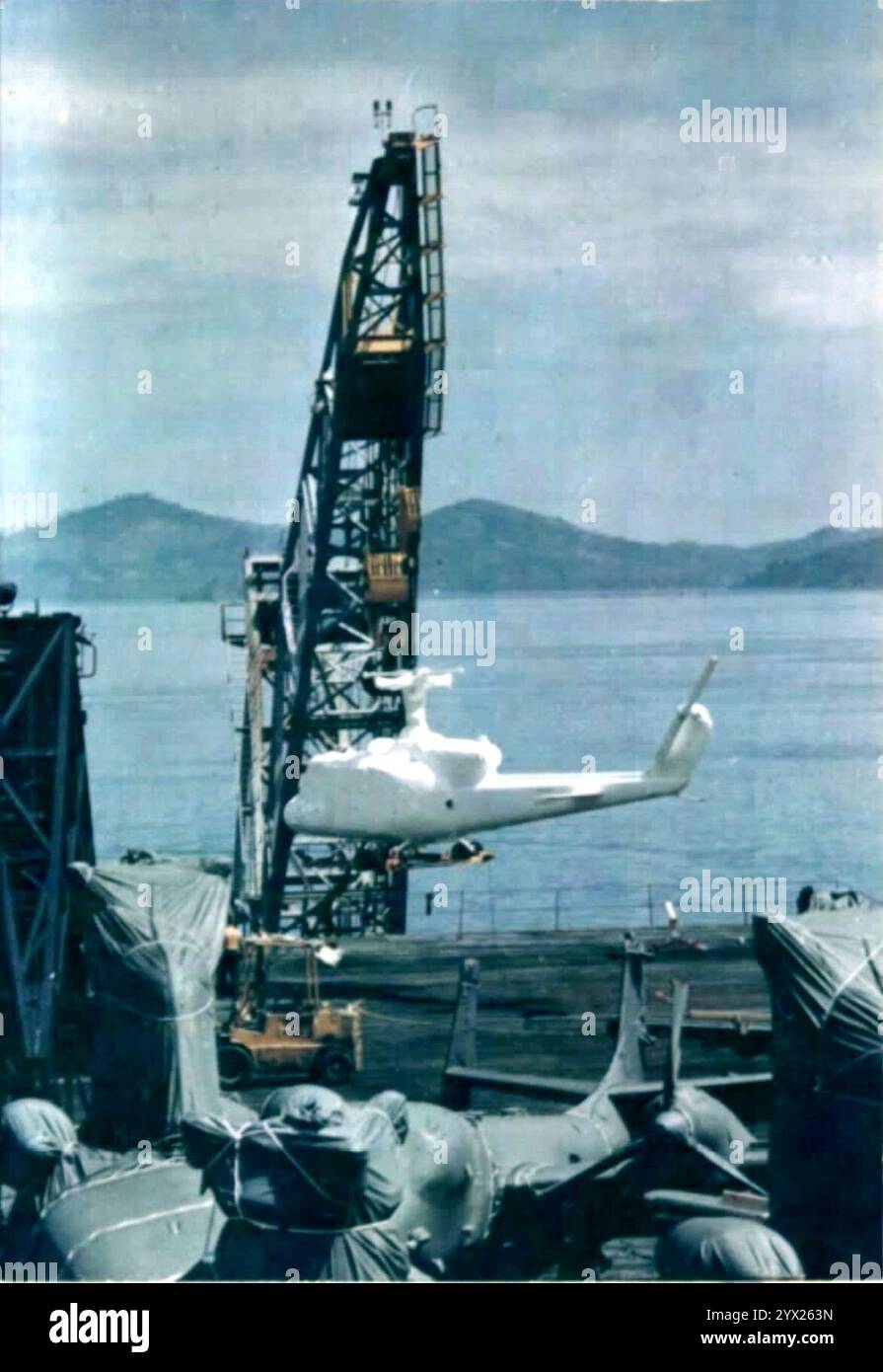 Crane lifts aircraft from USNS Breton (T-AKV-42) at NAS Cubi Point ...