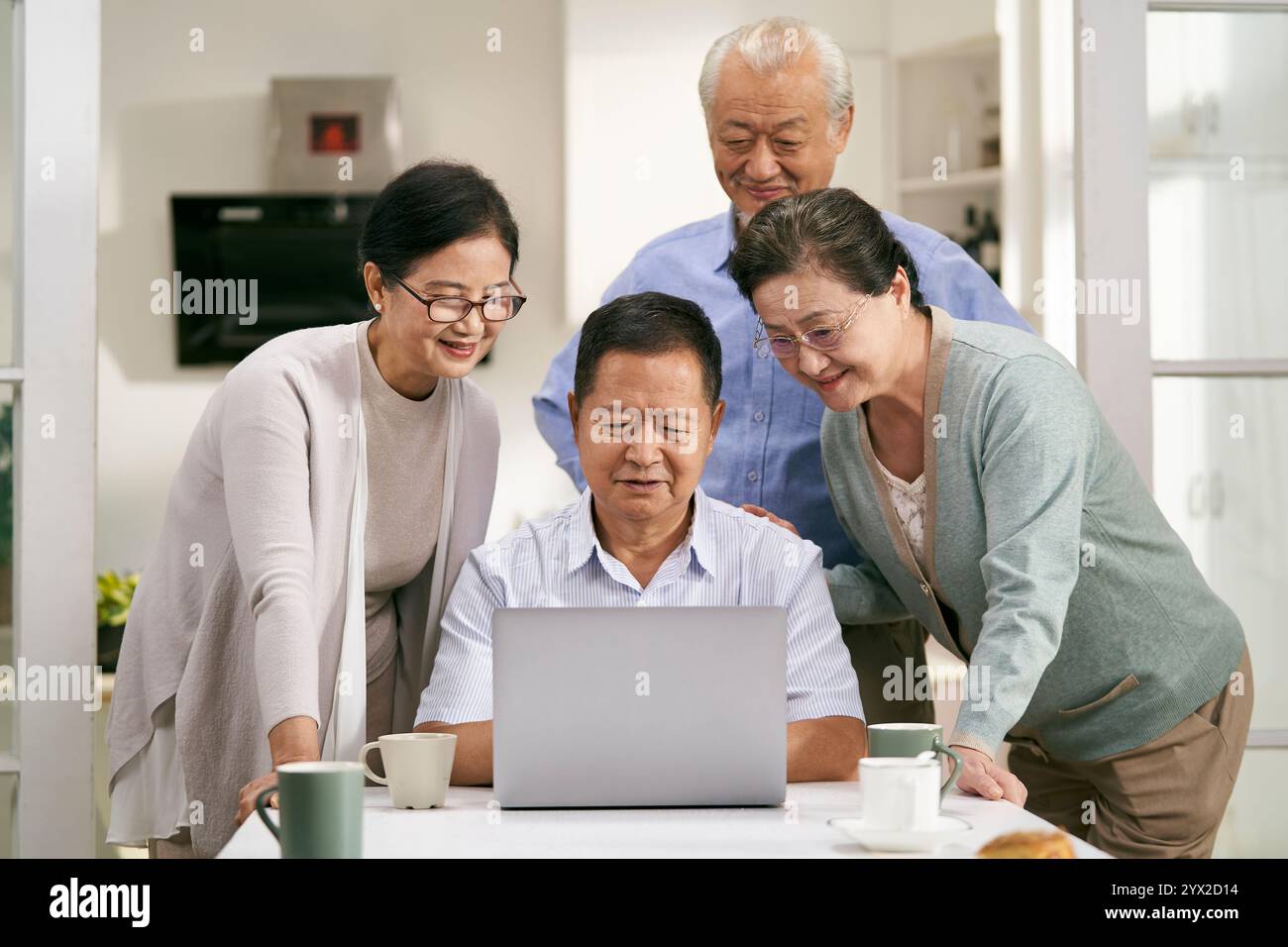 two happy asian couples using laptop computer together at home Stock ...