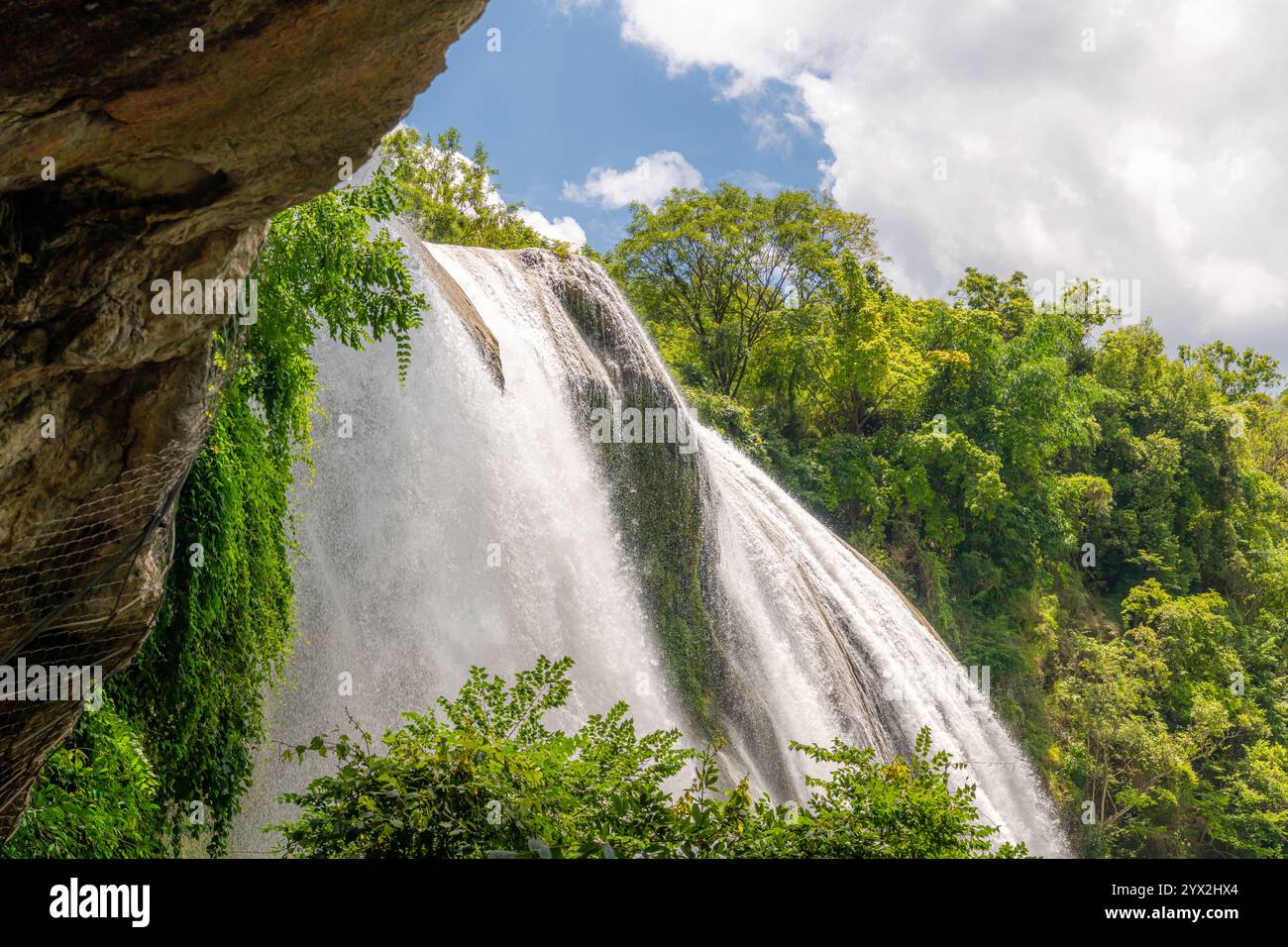 The waterfall interrupts violently the peaceful continuous flow of the ...