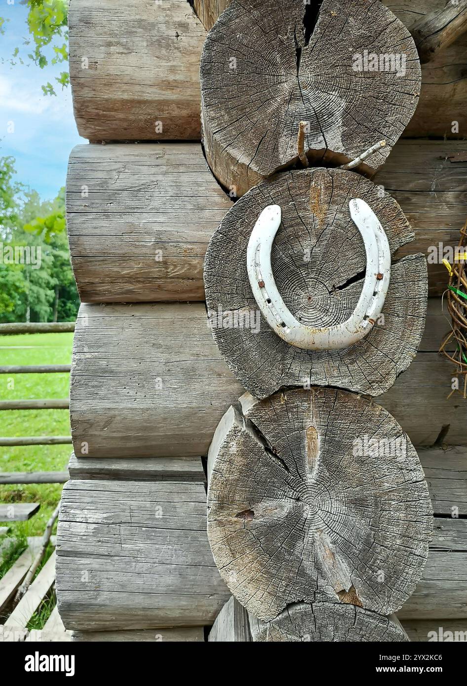 The corner of an old wooden log house is decorated with a metal ...