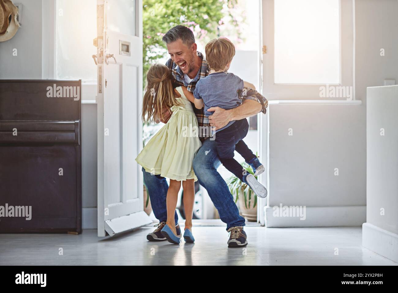 Excited, father and children with hug by door for welcome, greeting and ...