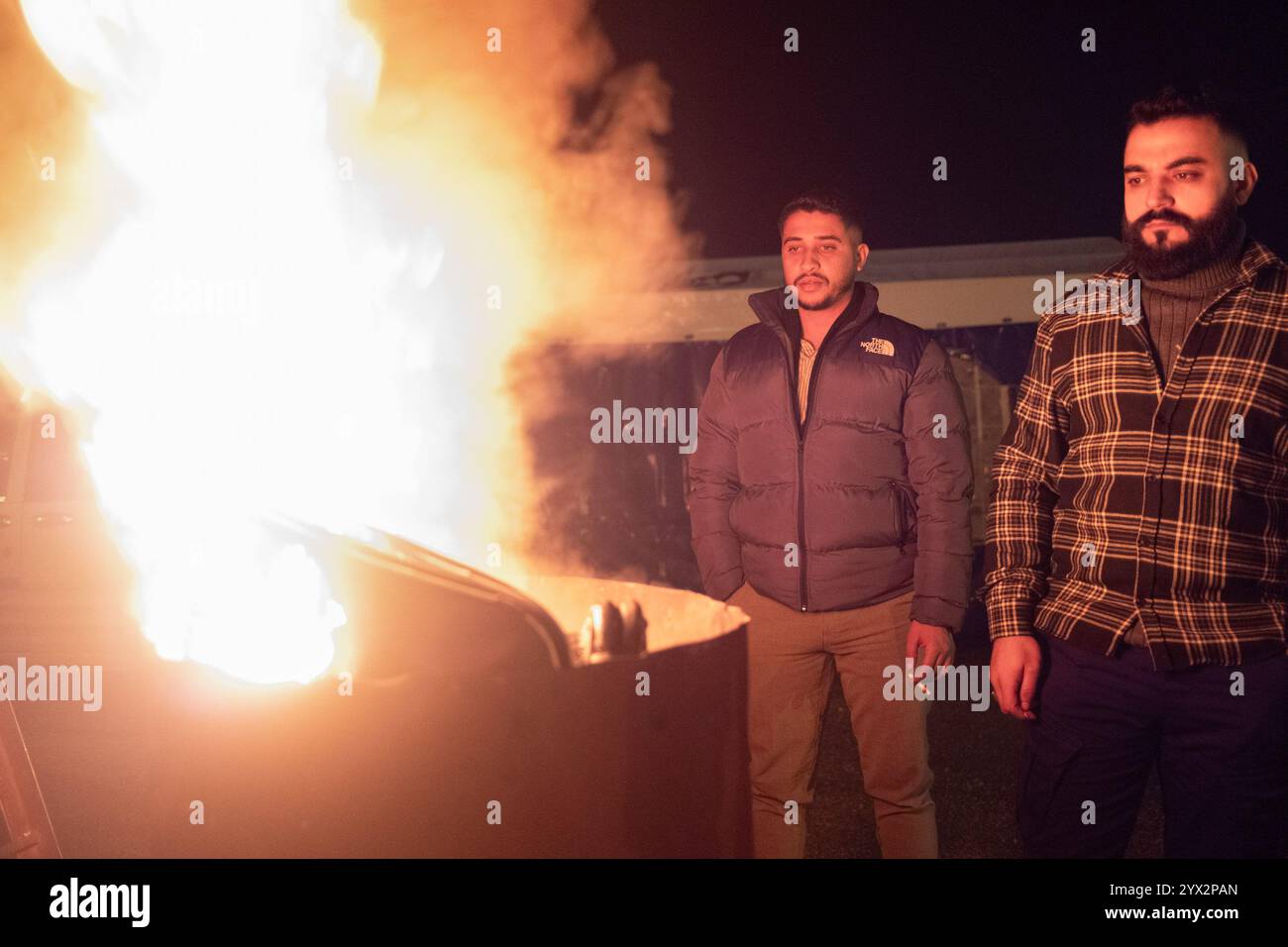 Syrian refugees keep warm by burning a suitcase that a family couldn't ...