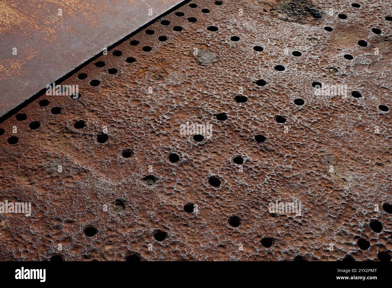 Rusty pitted & corroded, heavy iron plate with a series large of rivet ...