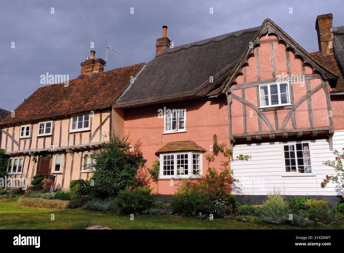 Pink half timbered, thatched roof cottages with gardens in Middle ...