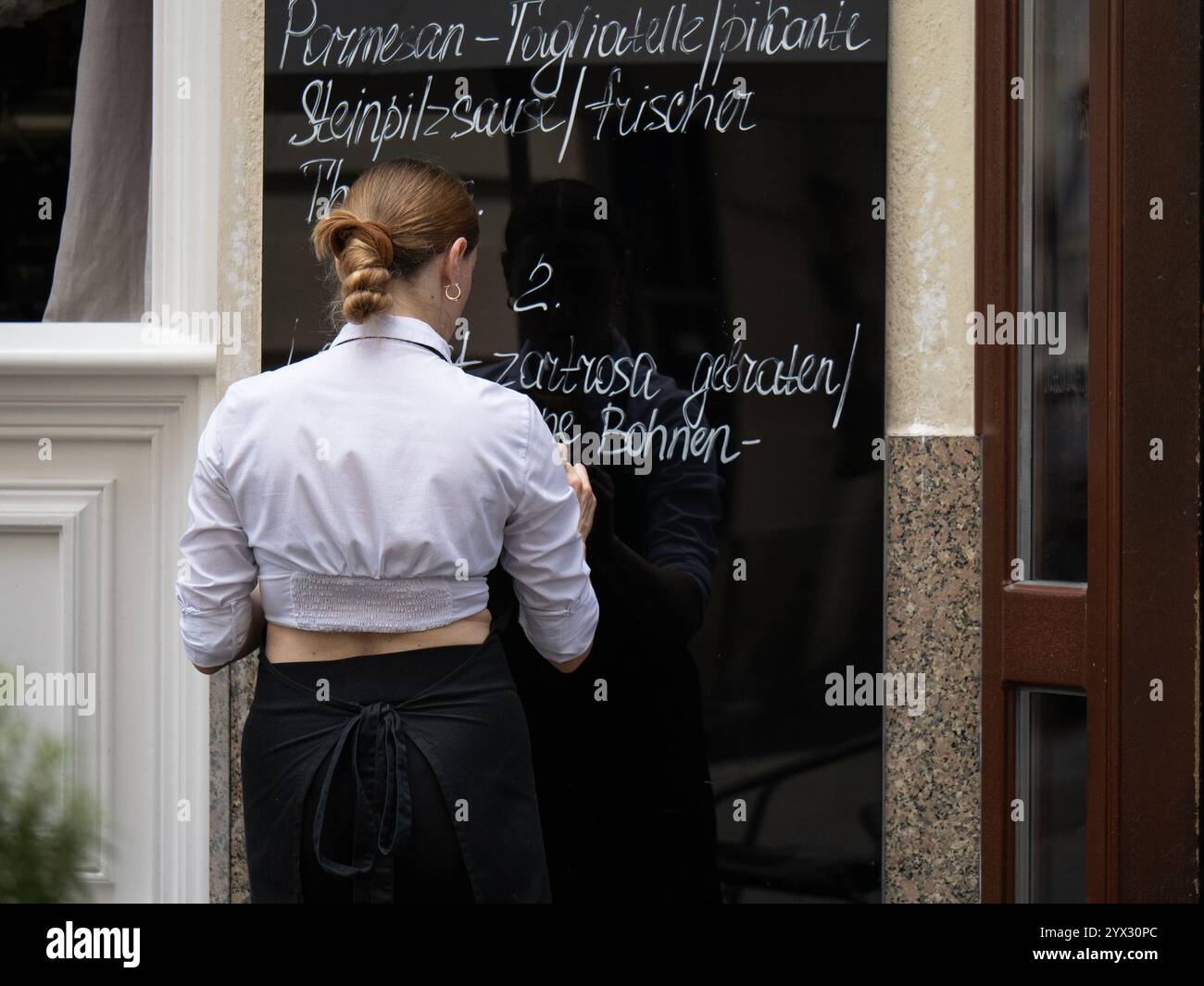 Waiter Writing the Menu of the Day on the Restaurant's Exterior ...