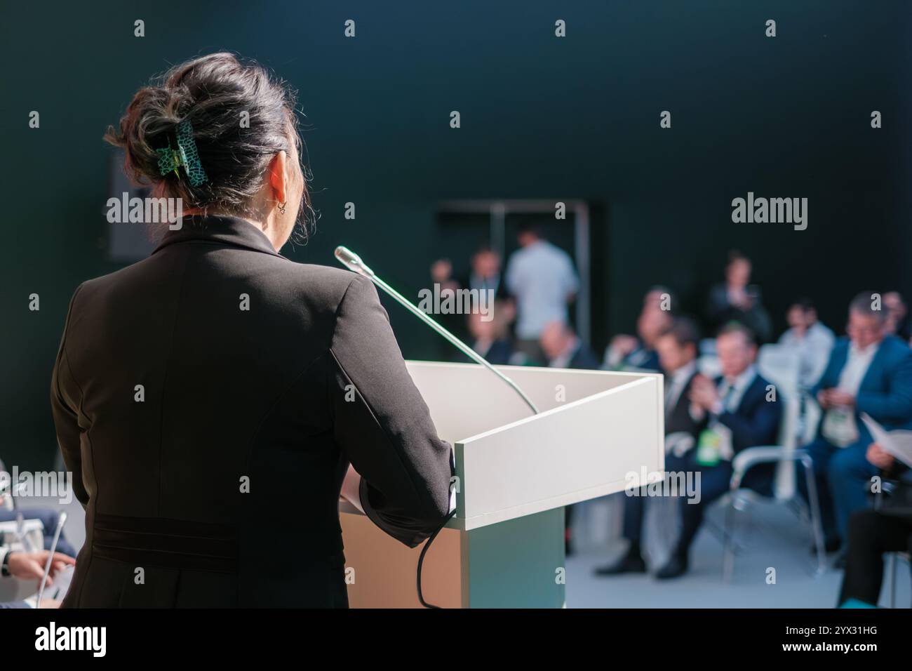Professional speaker addressing an audience at a business conference in ...