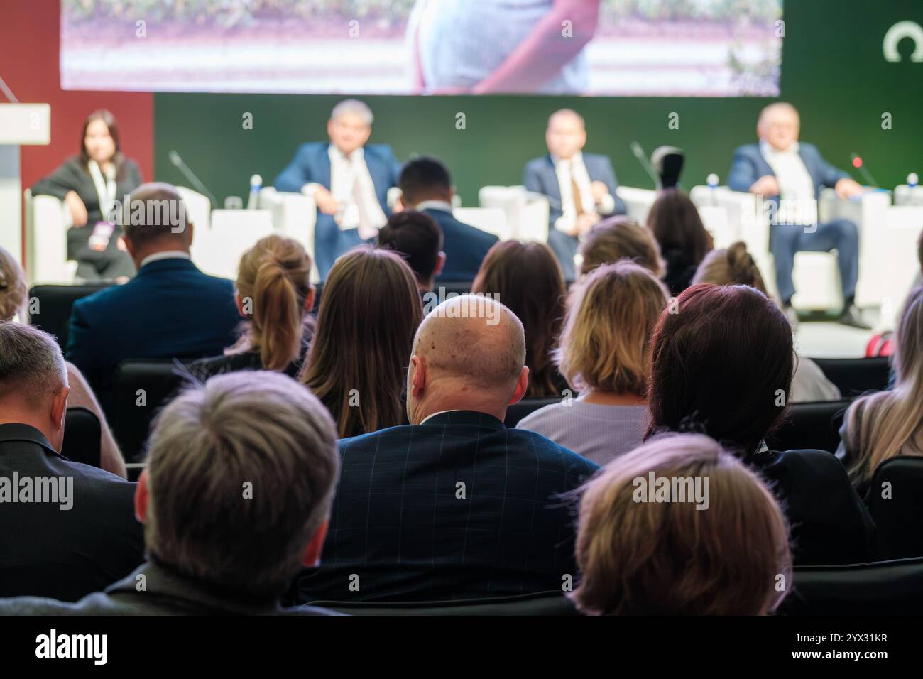Conference audience watching panel discussion with speakers on stage ...
