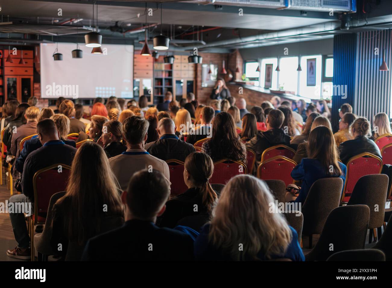 Audience listening to a speaker during a seminar in a modern conference ...