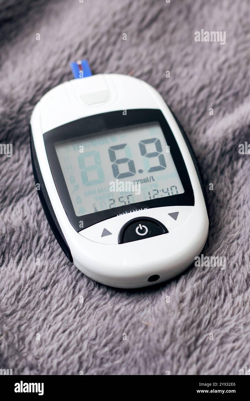 A glucose meter provides a reading alongside an insulin injection pen ...
