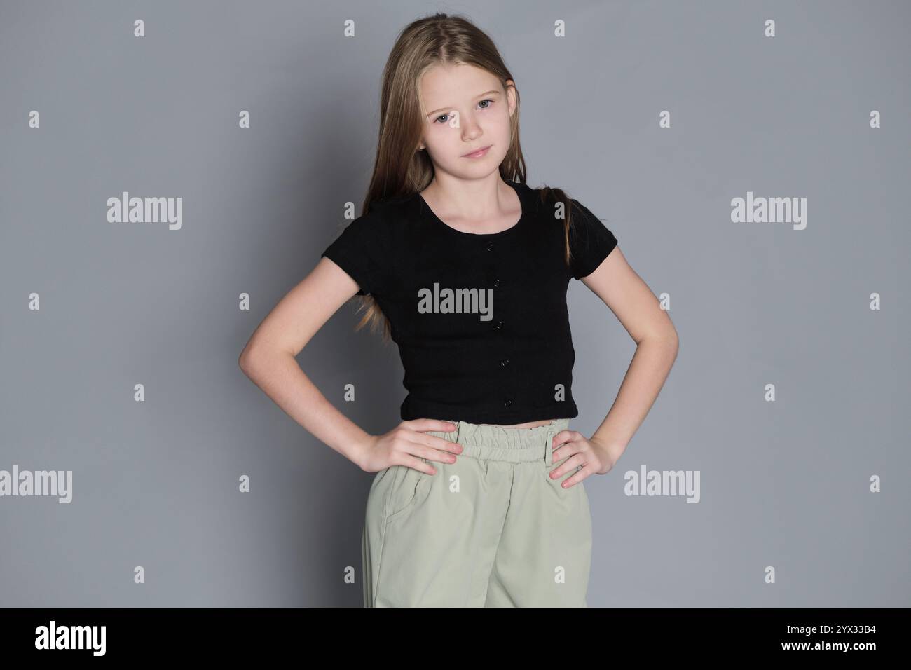 Poised and self-possessed, a young girl faces the camera. She ...