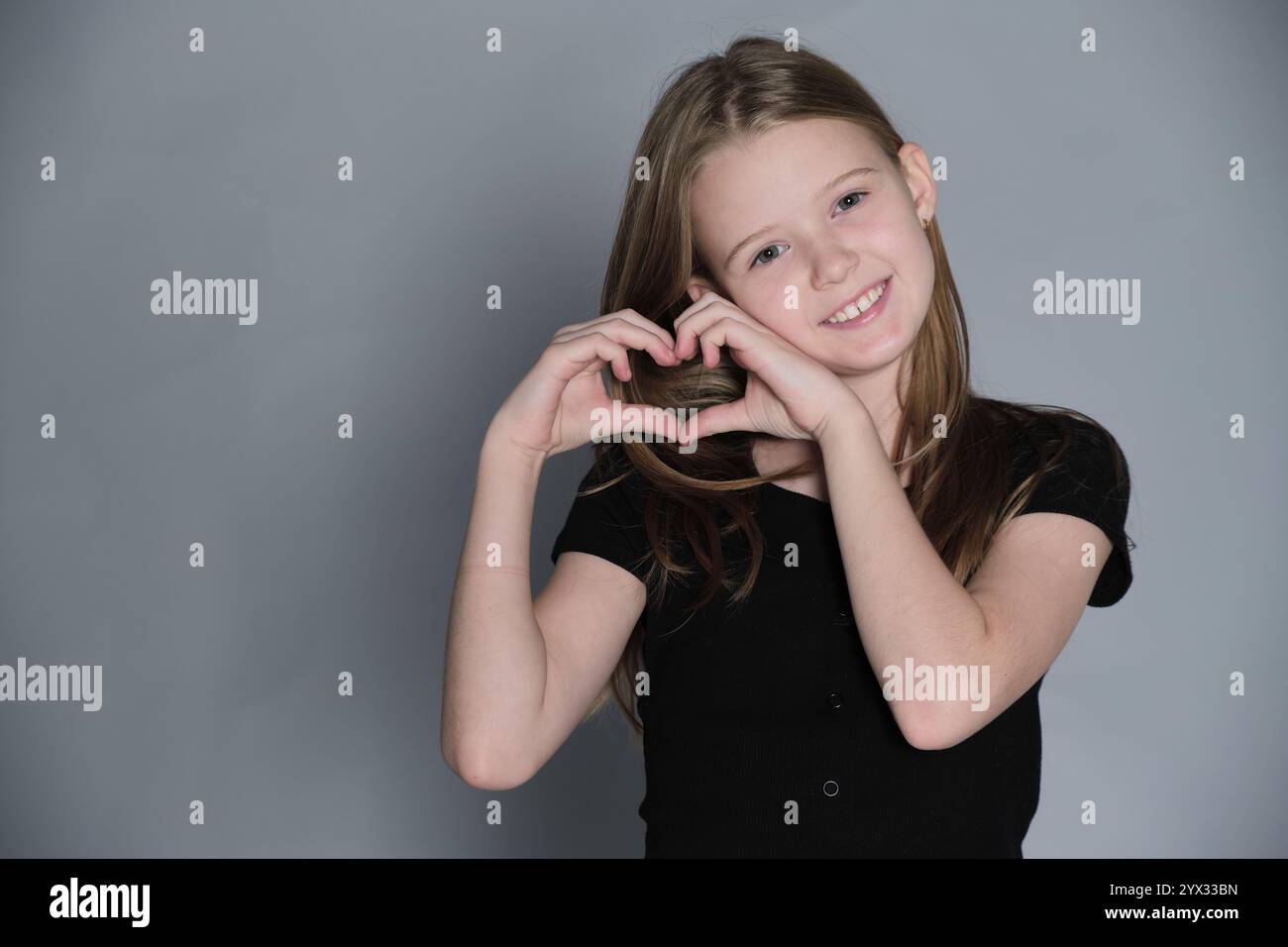 Girl shapes a heart with her hands, a universal sign of love. It ...