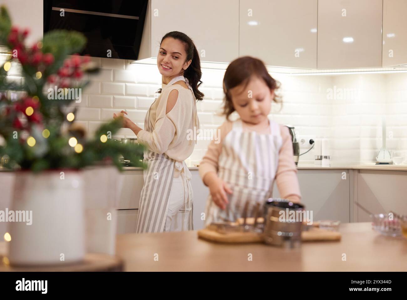 Cute little child girl in apron helping mom bake Christmas cookies in ...