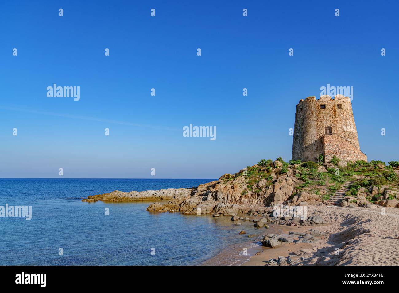 A beautiful seaside with an old brick tower in the foreground and a ...