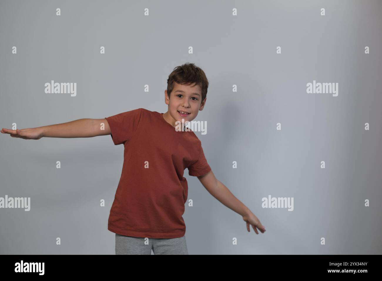 The boy's angled posture and genuine smile represent a candid moment ...